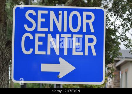 A blue sign instructs Senior Center ahead with an arrow pointing up ...