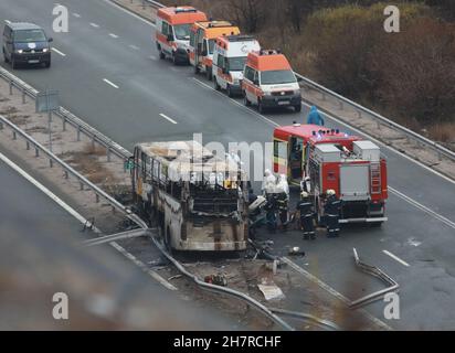 Firefighters inspect the scene of a bus crash on a highway near the ...