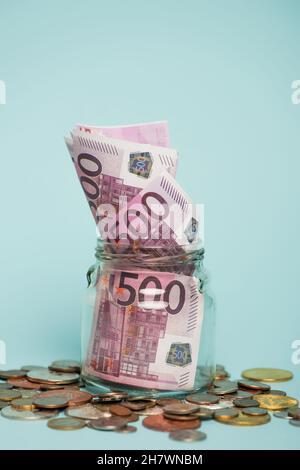 glass jar with euro banknotes near piggy bank on office desk, anti ...
