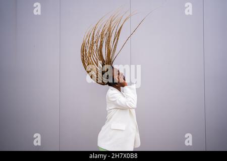 Photo with motion of a afro woman moving her hair to the back while ...