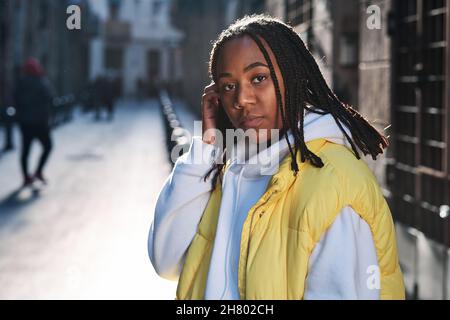 African american woman with braids standing over yellow background ...