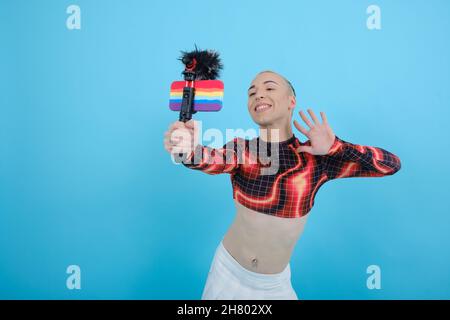 Non-binary social influencer person looking happy while vlogging online ...