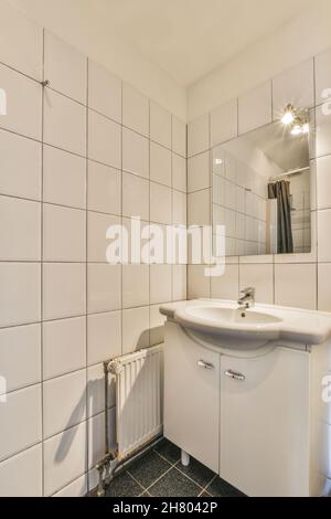 Interior of light bathroom with ceramic sink, table and shelving unit ...