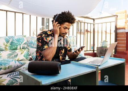 Concentrated African American male text messaging on cellphone while ...