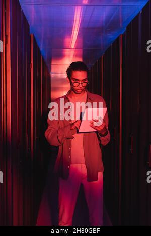 african american engineer in eyeglasses holding laptop while checking ...