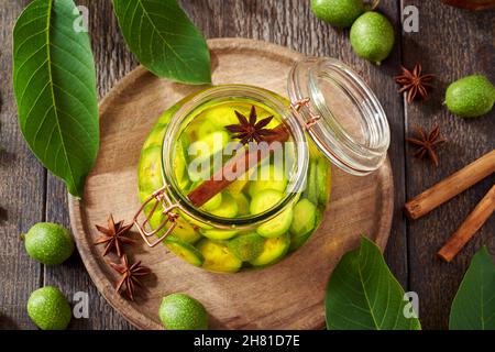 Macerating unripe walnuts in alcohol in a jar, to prepare homemade nut ...