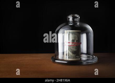 Saving money concept. Dollars under glass cap. Copy space Stock Photo ...