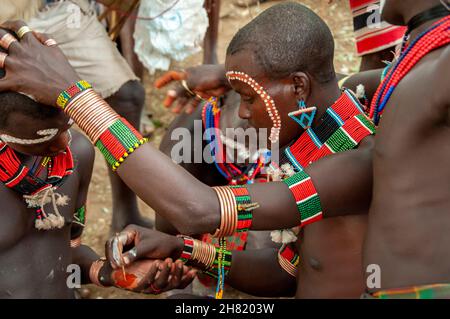 Men from the Hamar tribe painting each other for the initiation ritual ...