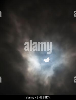 A partial solar eclipse is seen from a mosque's minaret next to a ...