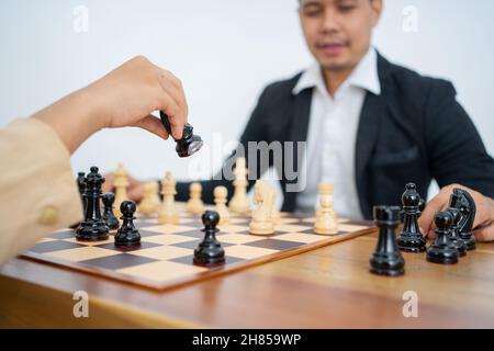 Hand holding chess piece against chessboard at school classroom Stock ...