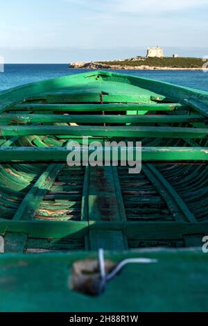 The Capo Passero Island (Cape Passero) with a boat of migrants ...
