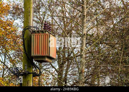 External transformer suspended on a wooden power bracket into electric ...