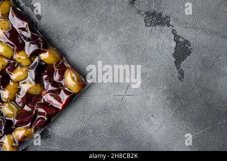 Greece olives in plastic pack, on black dark stone table background ...