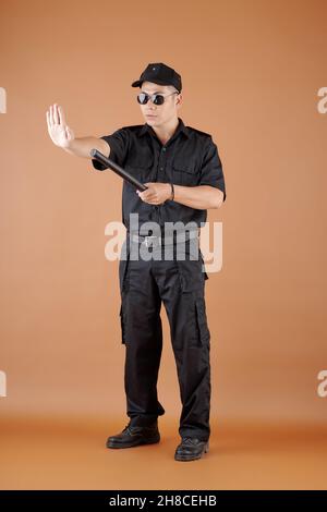 serious male police officer in bulletproof vest taking off sunglasses ...