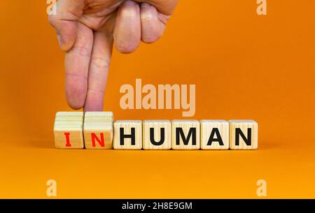 Human or inhuman symbol. Businessman turns wooden cubes and changes the ...