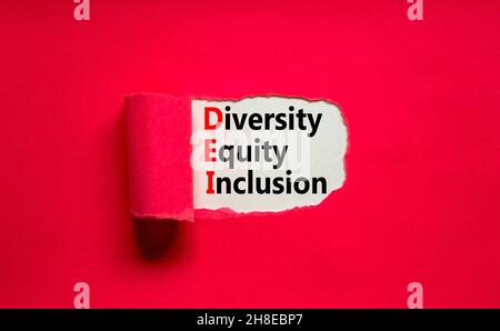 Diversity, equity, inclusion appearing behind torn paper background ...