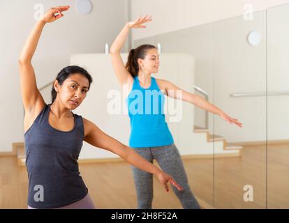 Hispanic woman practicing classic dance moves during group class Stock ...