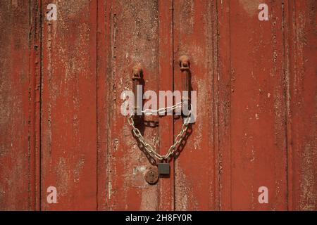 A burgundy double wooden door chained closed Stock Photo - Alamy