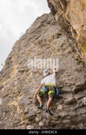 Handsome rock climber preparing for training. Shallow depth of field ...