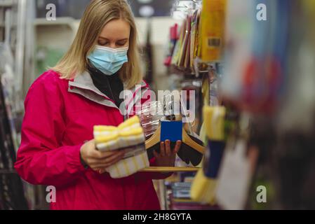 Woman in medical mask chooses rag for floor cleaning Stock Photo - Alamy