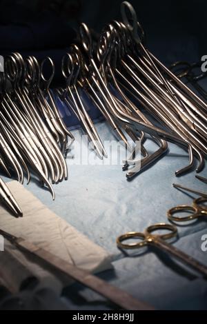 Set of steel surgical tools on blue cloth - real instruments used in ...