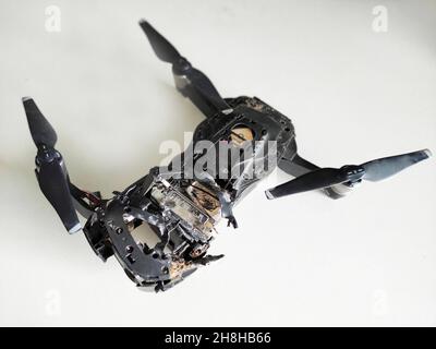 Broken black quadcopter drone uav lying on green grass lawn on ground ...