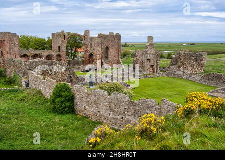 View of Lindisfarne Priory ruins and Lindisfarne village on Holy Island ...
