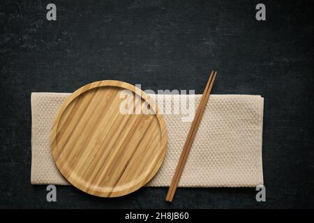 Empty plate with wooden sticks for Asian food on a dark concrete ...