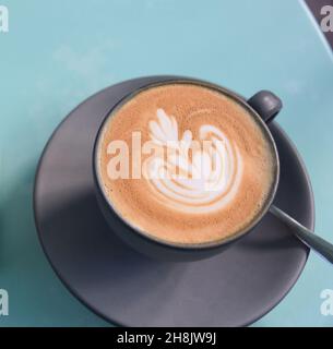 Coffee espresso in a fancy cup, wooden table, silver teaspoon Stock ...