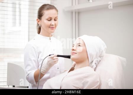 Young woman having micro current galvanic facial treatment with ...
