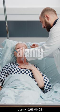 Doctor and nurse giving assistance to heavy breathing woman, using ...