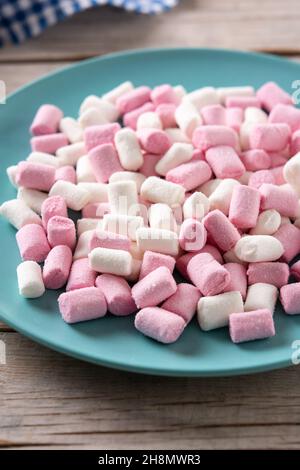Sweet marshmallows topping in a blue plate on wooden table Stock Photo ...