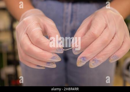 Professional placing the jewel of piercing on the temple on the head ...