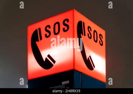 Red illuminated SOS Sign with telephone in Detail Stock Photo - Alamy