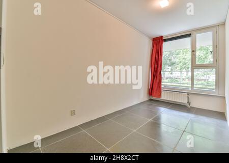 Interior of spacious empty room with tiled floor with white wooden ...