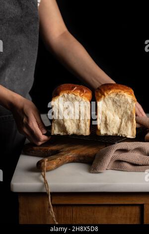 Unrecognizable crop baker taking split halves of sandwich bread from ...