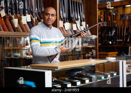 Hispanic salesman showing collectible rifled musket in gun store Stock ...