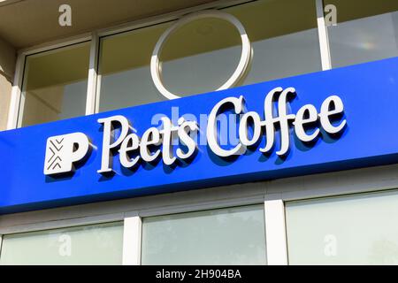 Peets Coffee logo on exterior of gray building against clear blue sky ...