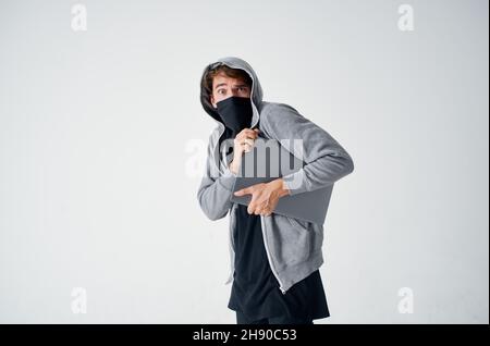 male thief hooded head hacking technology security light background ...