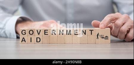 Wooden blocks with symbol of government aid concept Stock Photo - Alamy