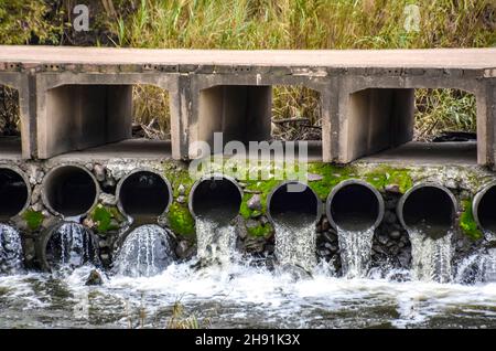 A concrete road on top of multiple sewage pipes redirecting water as a ...