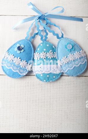 Handmade patchwork blue felt easter eggs on white wooden table Stock ...