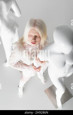 overhead view of blonde albino woman with tattoo looking at camera ...