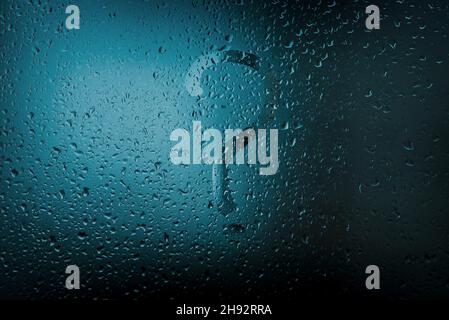 A question mark on rain-wet glass. Water drops on the window. Question ...