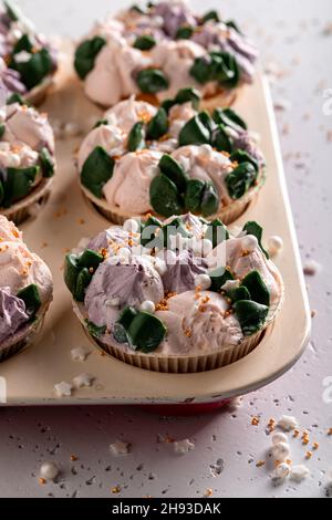 Unique cupcakes made of sprinkles and purple whipped cream. Purple dessert with golden sprinkles ...