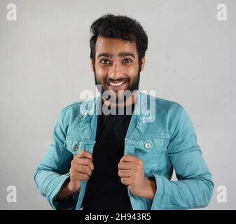Happy shy young hispanic man smiling and look down Stock Photo - Alamy