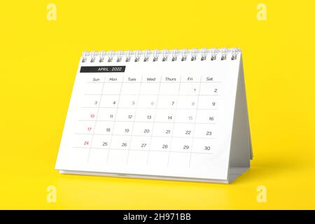 Flip paper calendar for April 2022, notebook, houseplant and calculator ...