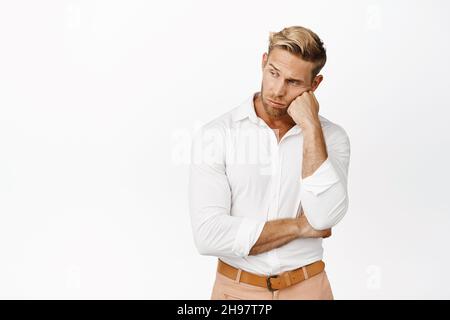 Portrait of disappointed and sad handsome blond asian guy, sulking ...