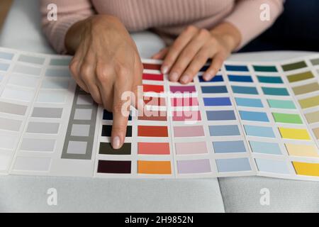 Close-up of woman hands painting an easter egg on wooden background ...