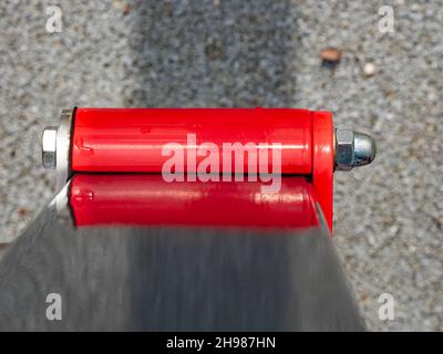 Red horizontal bar screwed with painted vertical frame construction ...